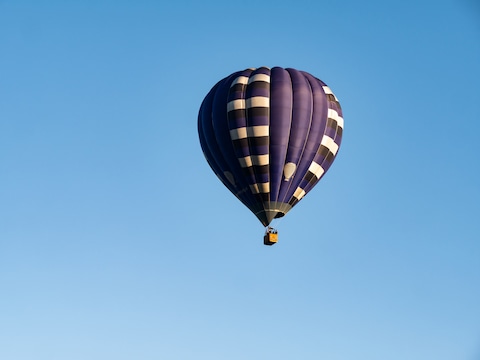 Un passager saute d’une montgolfière au-dessus d’un village aux Pays ...